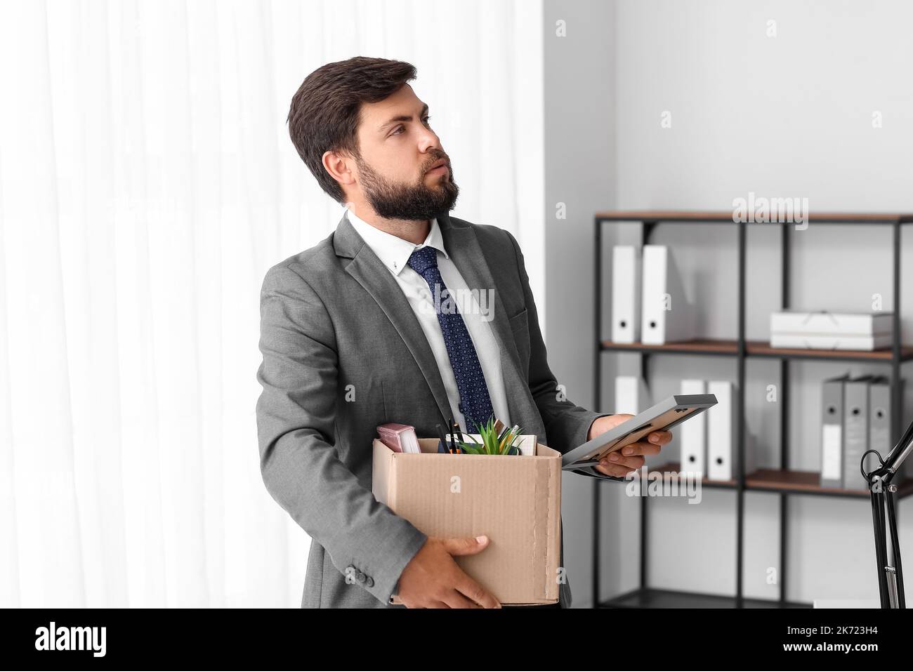 Fired young man holding box with his stuff in office Stock Photo - Alamy
