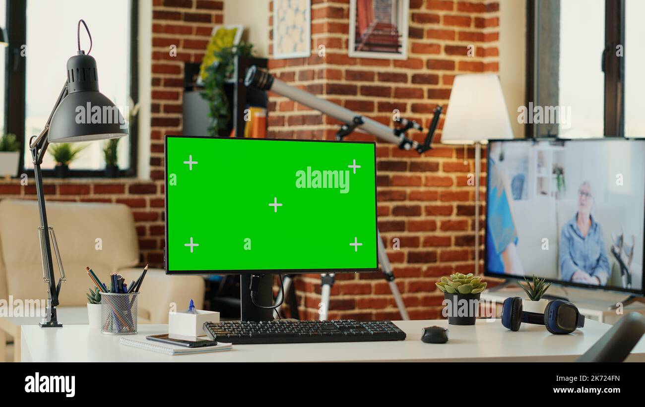 Empty office desk with greenscreen template on monitor, isolated mockup background running on ...