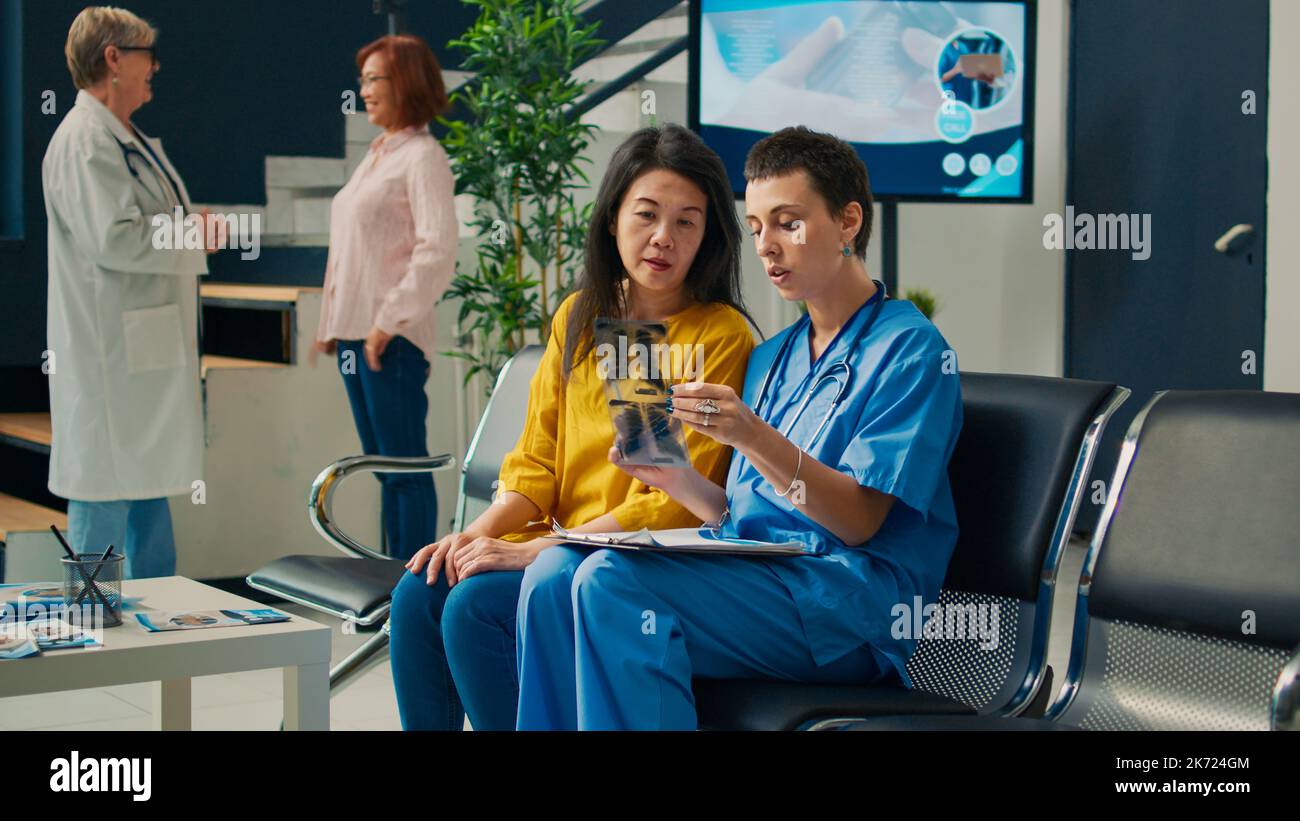 Health specialist showing radiography scan diagnosis to patient in ...