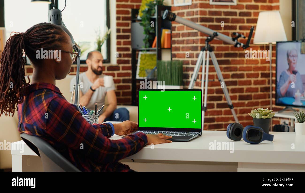 African american woman working with greenscreen display on laptop ...