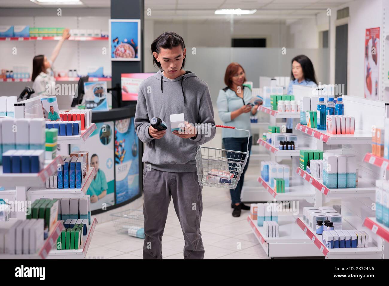 Undecisive customer reading medicine packages in pharmacy, looking at ...