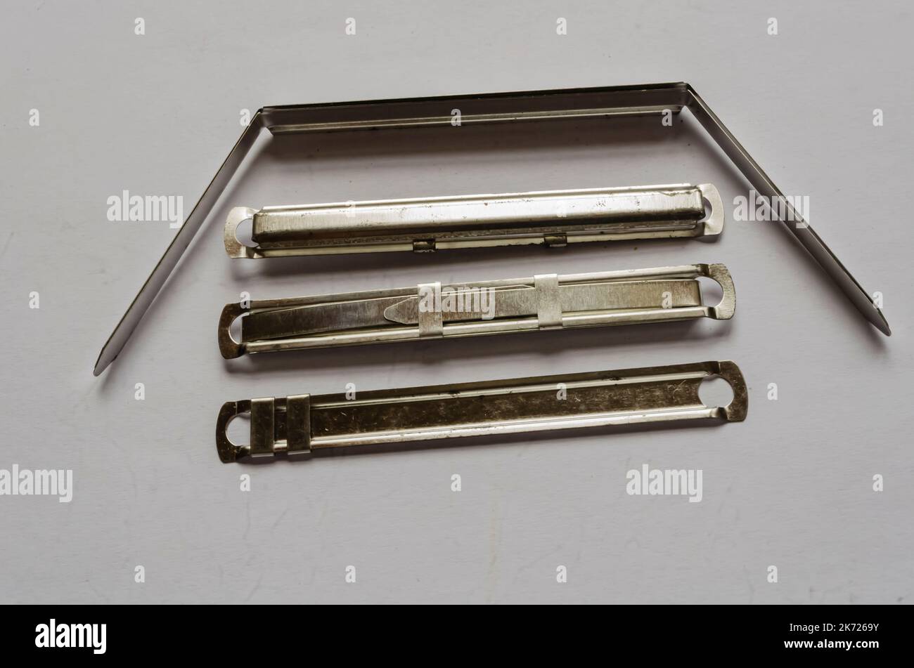 An open fastener pring and its compressor are beside two other ...