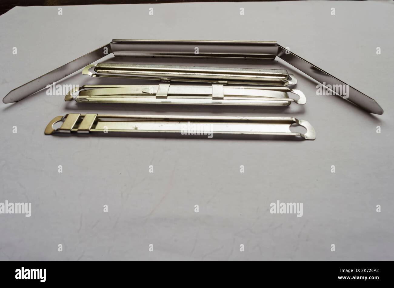 An open fastener pring and its compressor are beside two other ...