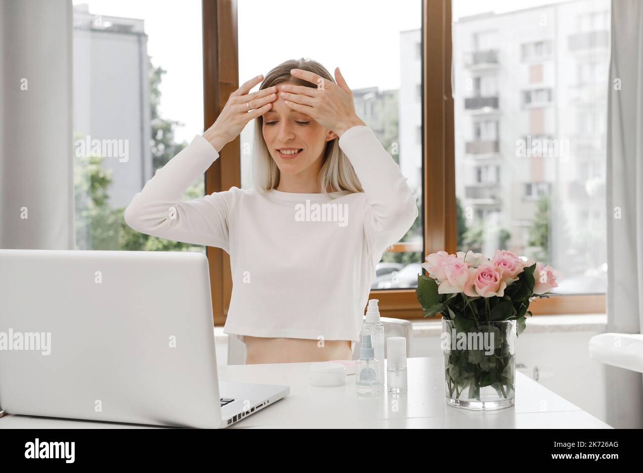 self face massage on-line course near laptop. Woman doing anti-age ...