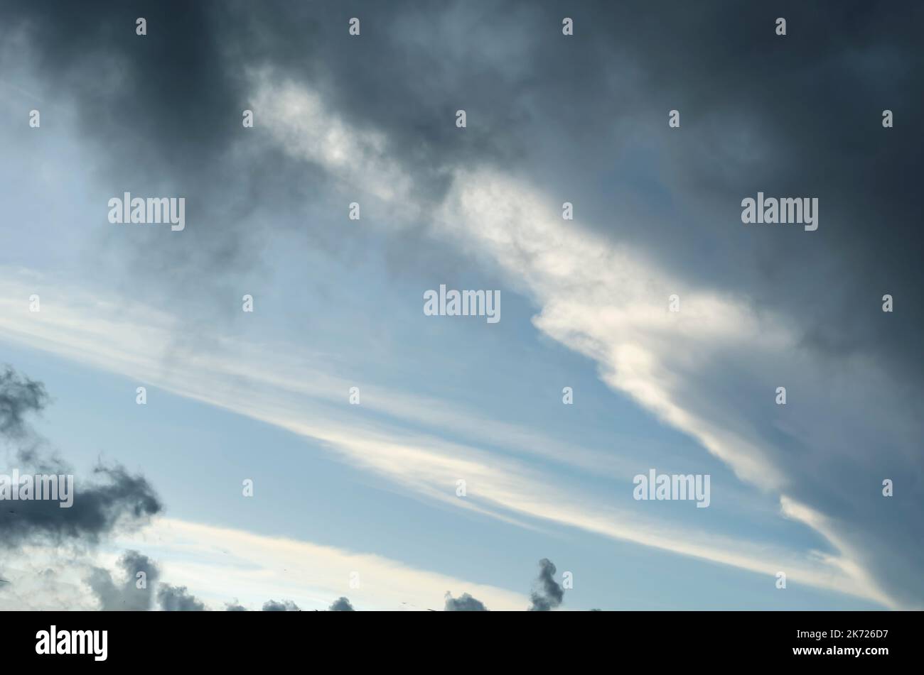 Layers of nimbus and stratus clouds are across the blue of the sky ...