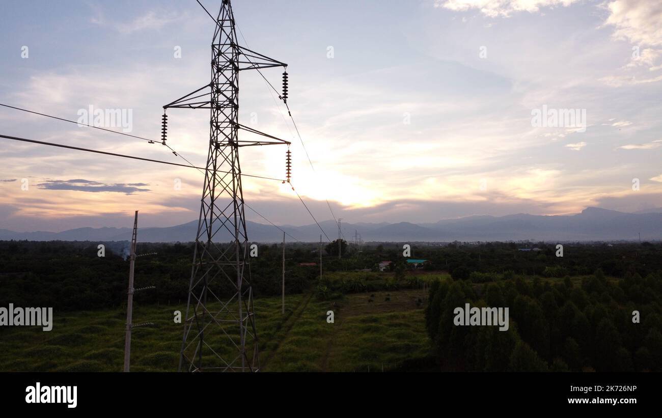 Aerial view of high voltage pylons and wires in the sky at sunset in ...
