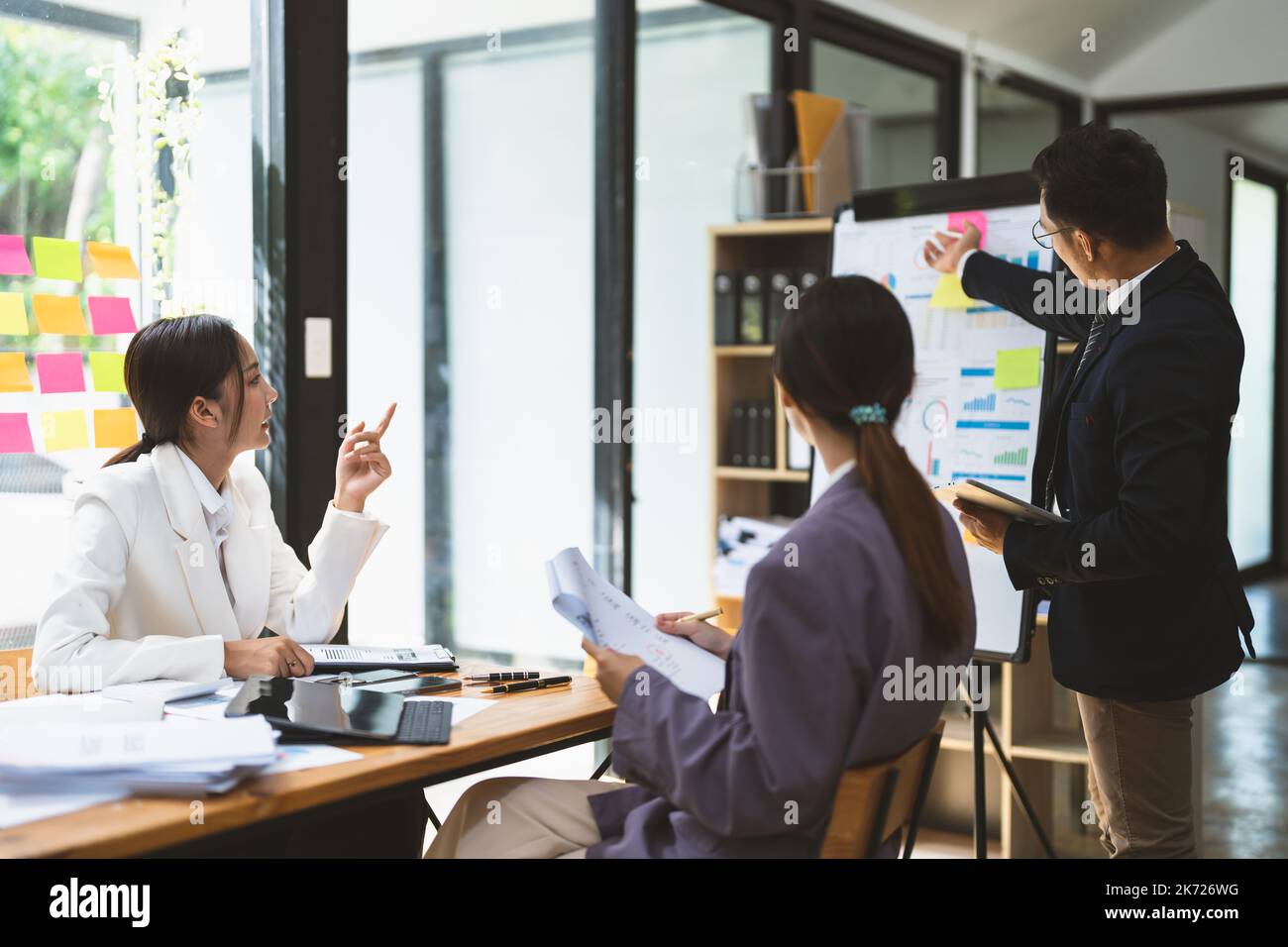 Business adviser explaining business plan strategy on flipchart to ...