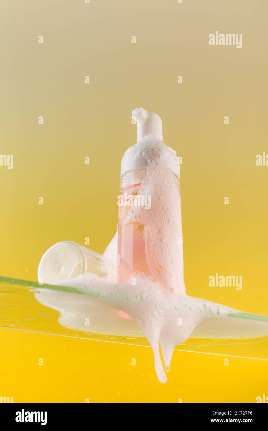 Dispenser mockup with face wash foam on a glass shelf. Acne remover ...