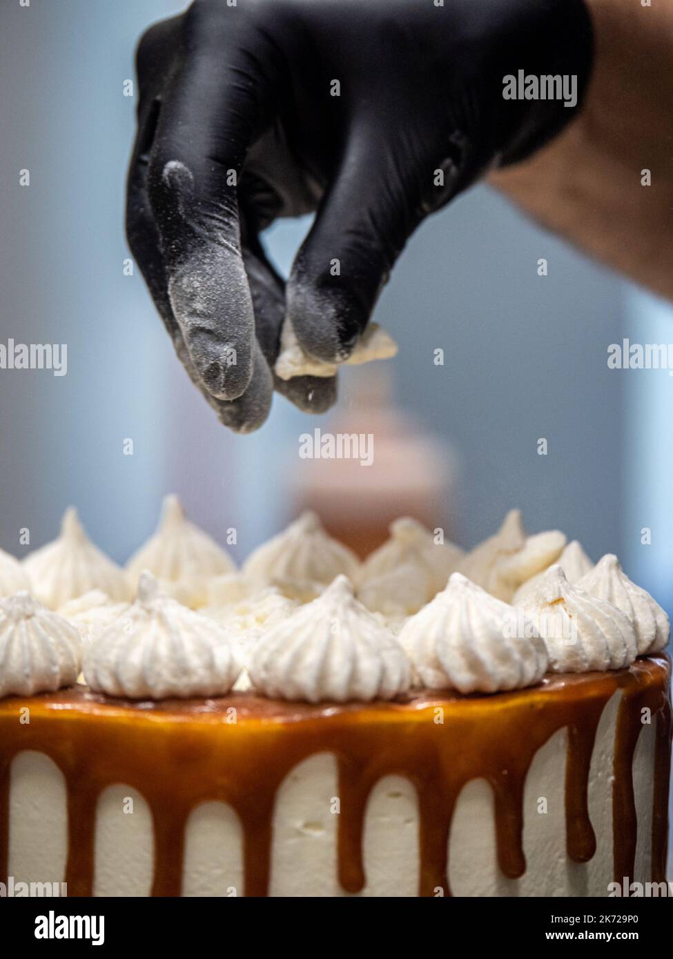 cake desginer topping a sweet icing caramel cake Stock Photo - Alamy