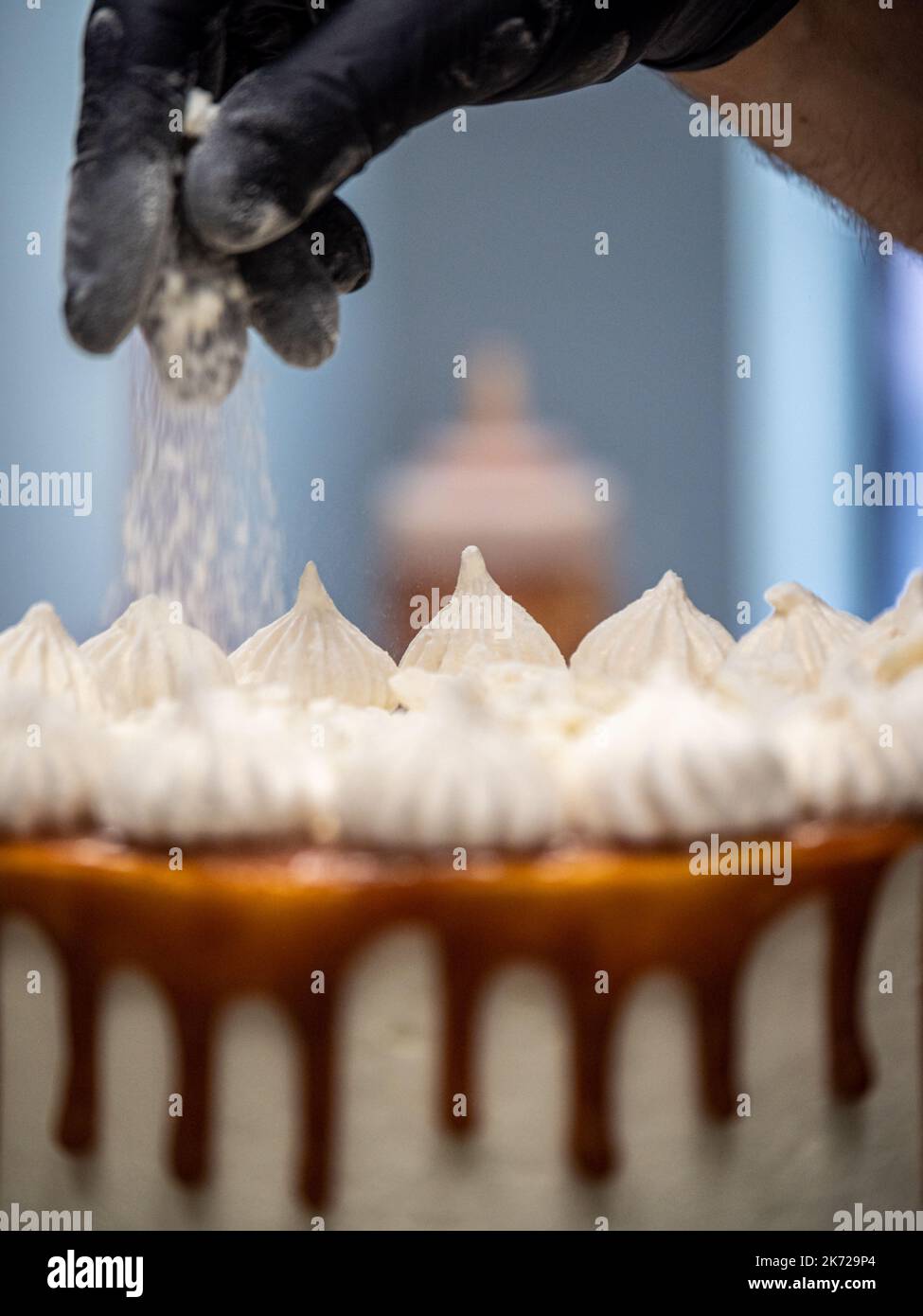 cake desginer topping a sweet icing caramel cake Stock Photo - Alamy