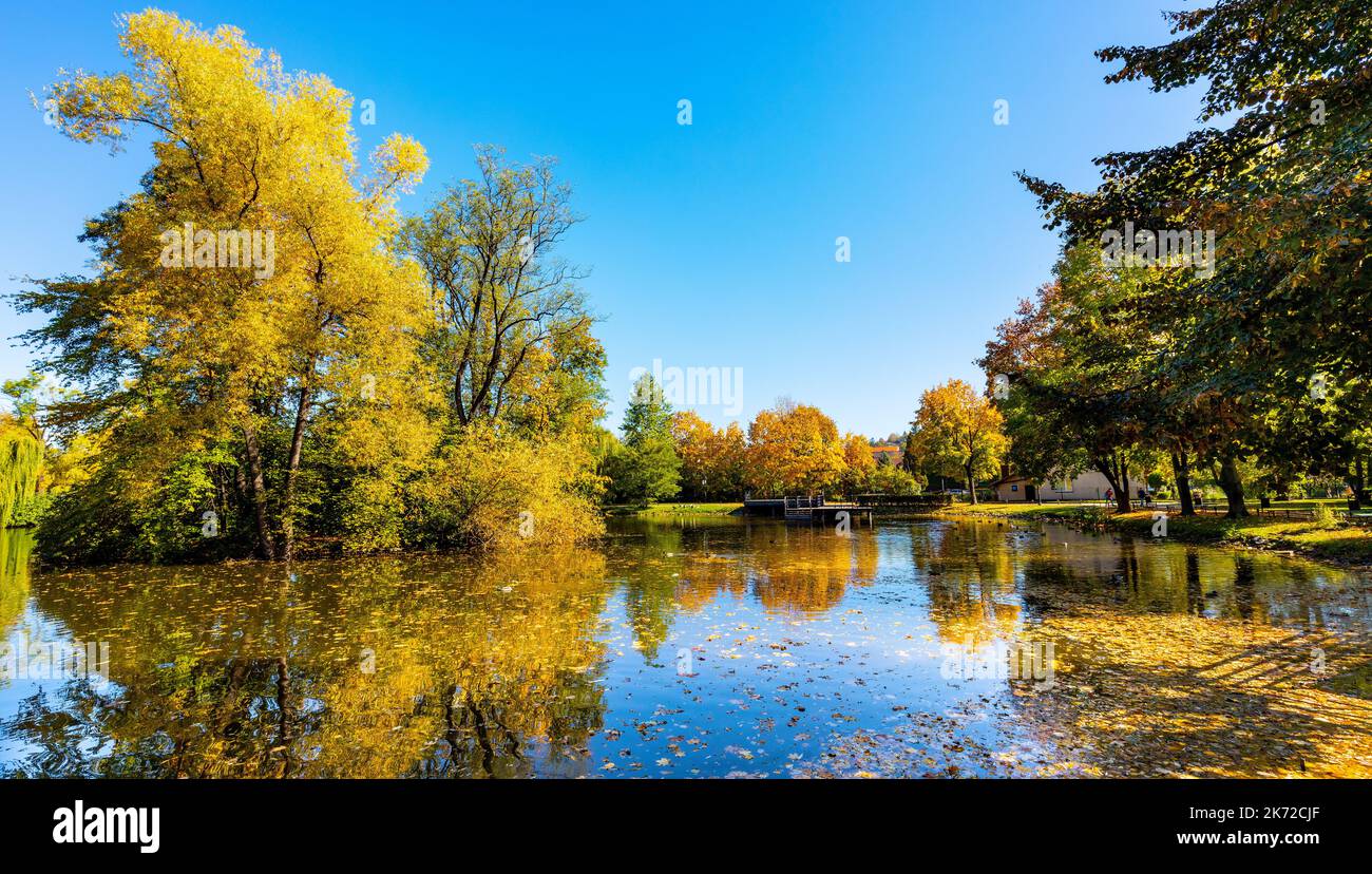 City park and lake with colorful fall trees in historic old town ...