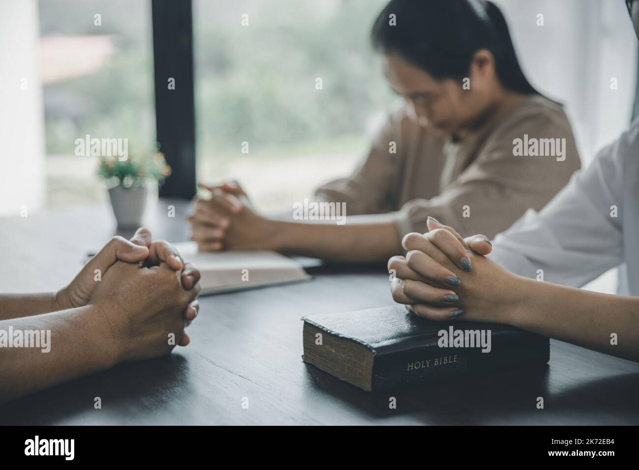 Pray among, Young woman praying among other religious people indoors ...