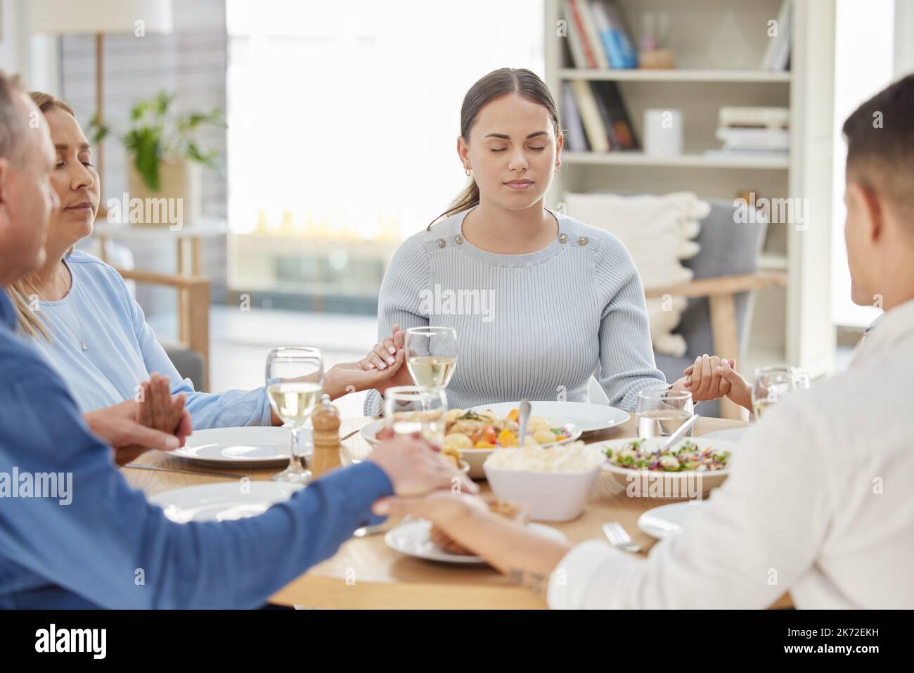 We thank you. a beautiful family blessing the food with a prayer at the ...