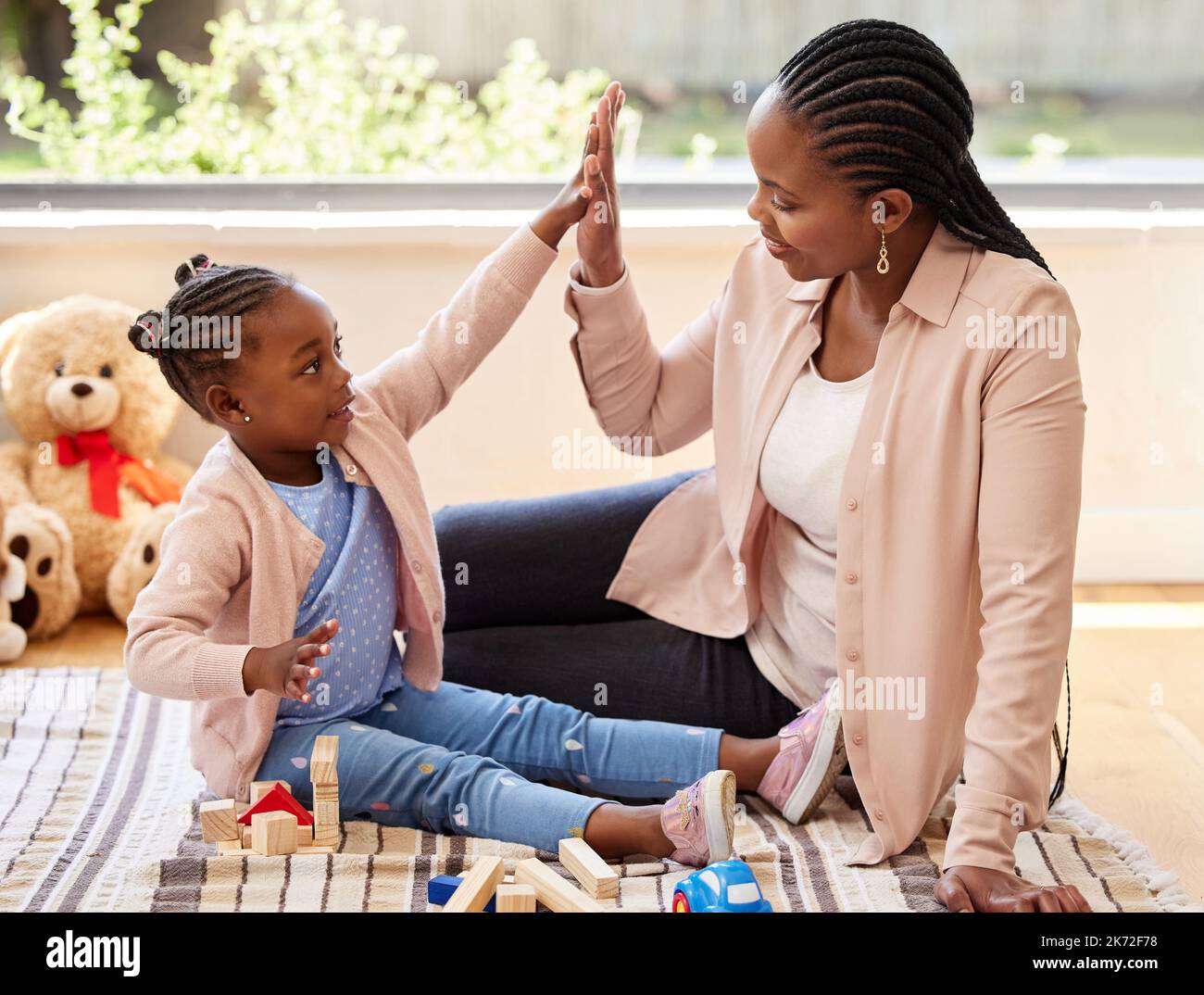 Great job. a little girl giving her mother a high five while playing at ...
