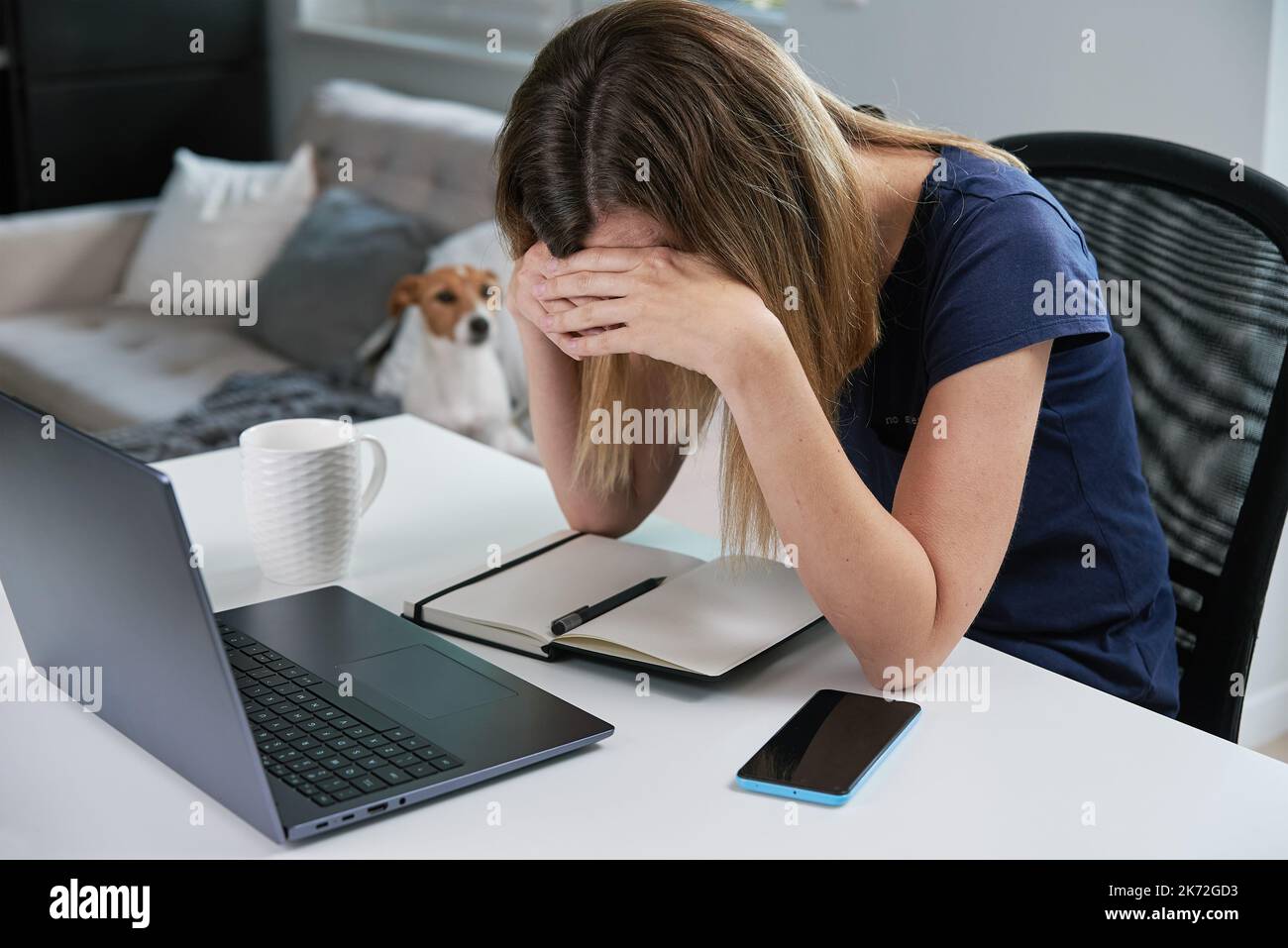 Thirty years old tired woman working late remotely at home office ...