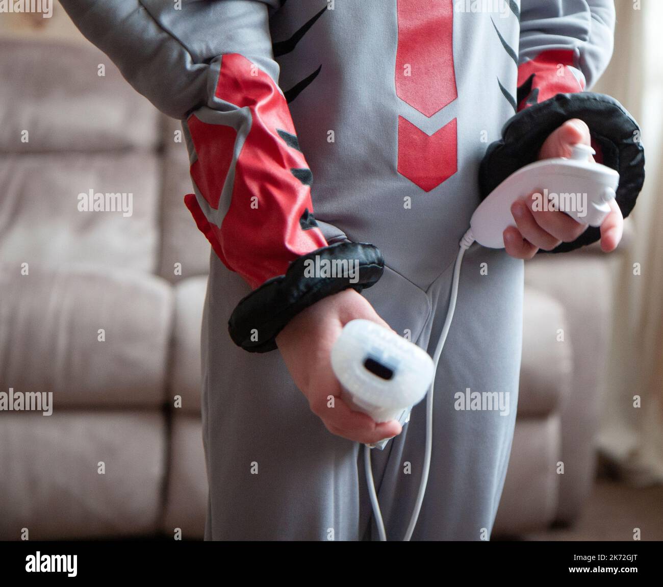 Young boy wearing a super hero outfit and holding a Nintendo Wii Remote ...