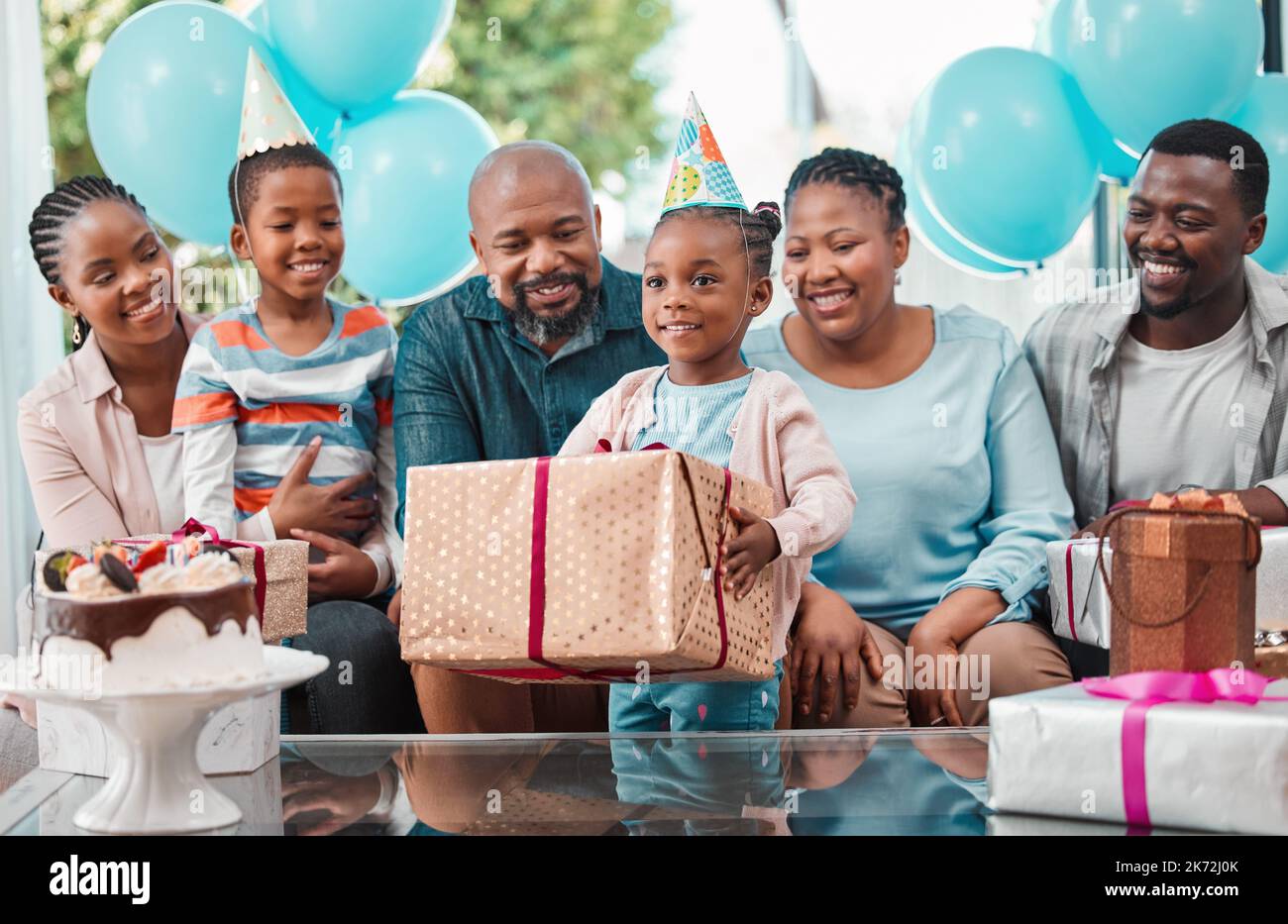 I wonder whats in this one. a little girl opening gifts at her birthday ...