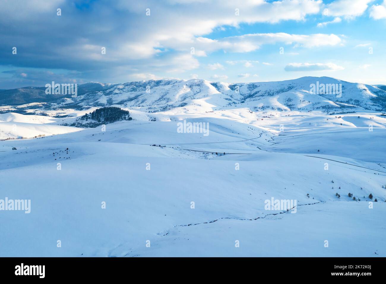 Aerial shot of beautiful snow capped mountains and hills winter ...