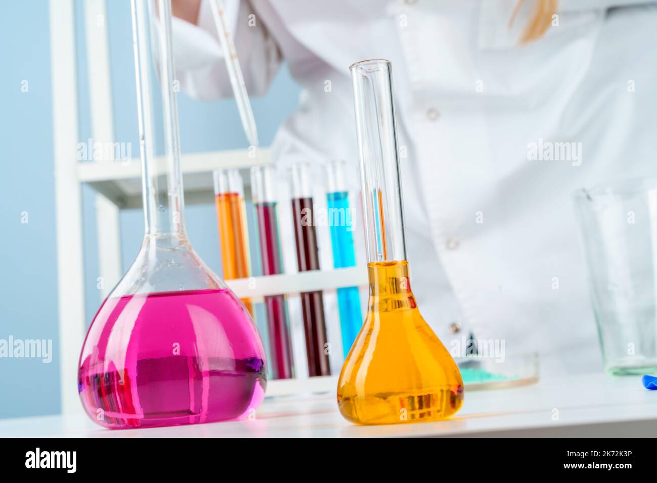 Colored liquids inside lab glassware on white table in laboratory Stock ...