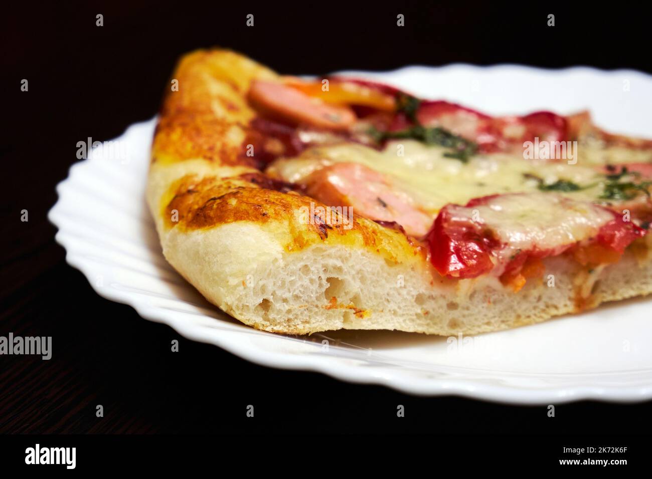 Pizza slice on white plate side view Stock Photo - Alamy