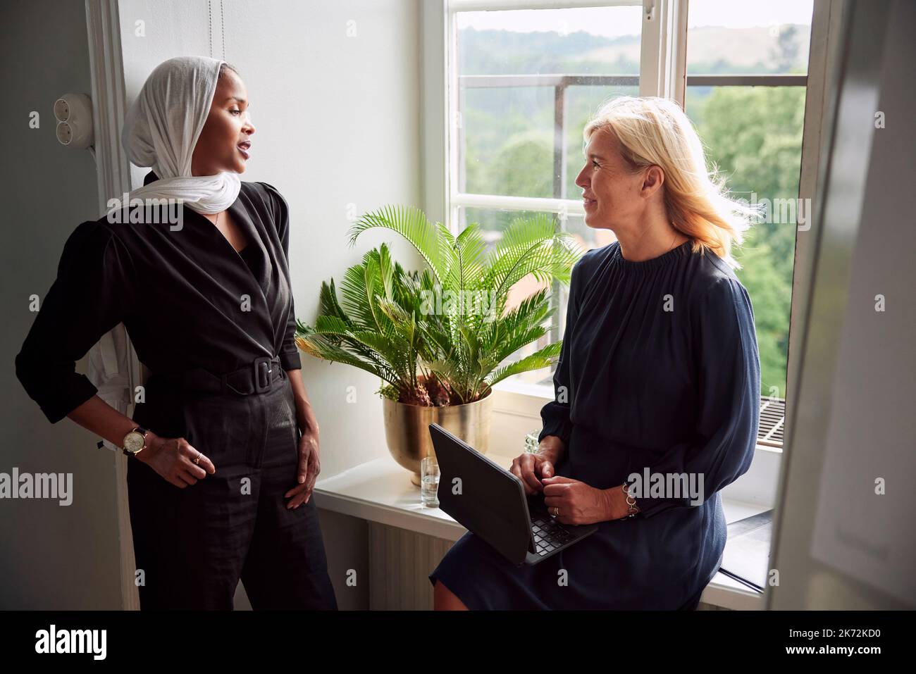 Two women sit together looking hi-res stock photography and images - Alamy