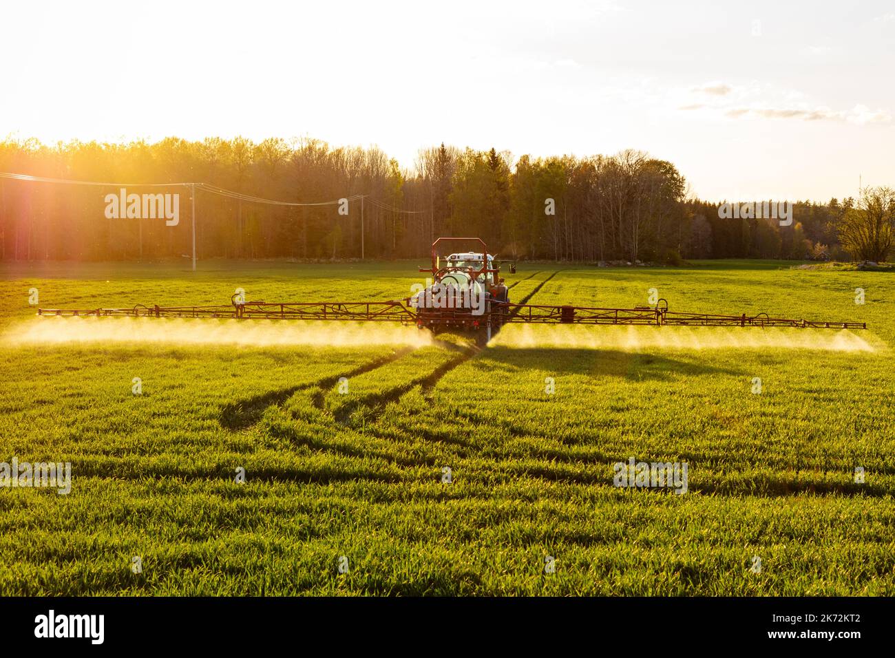 Tractor spraying field Stock Photo - Alamy
