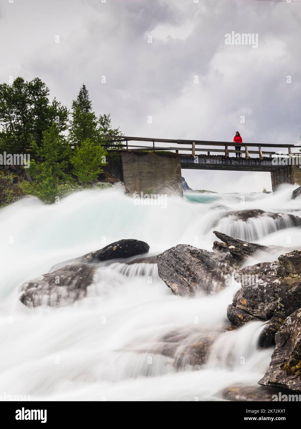 Hiker standing on bridge over river Stock Photo - Alamy