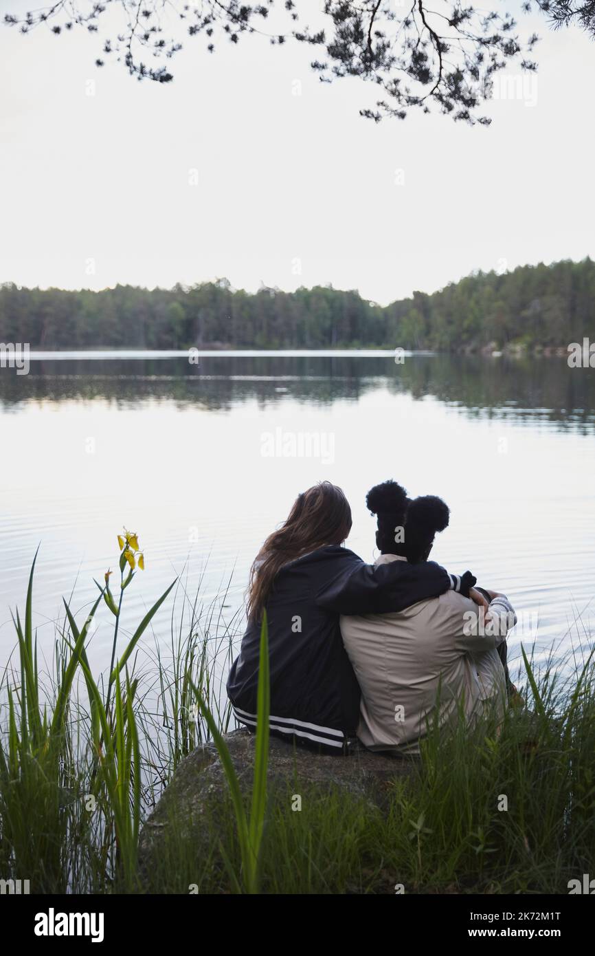 Female friends embracing at lakeshore Stock Photo - Alamy