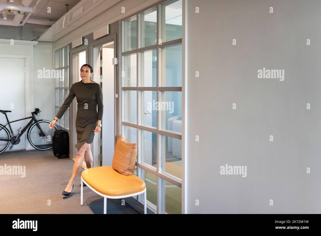 Woman walking in office Stock Photo - Alamy