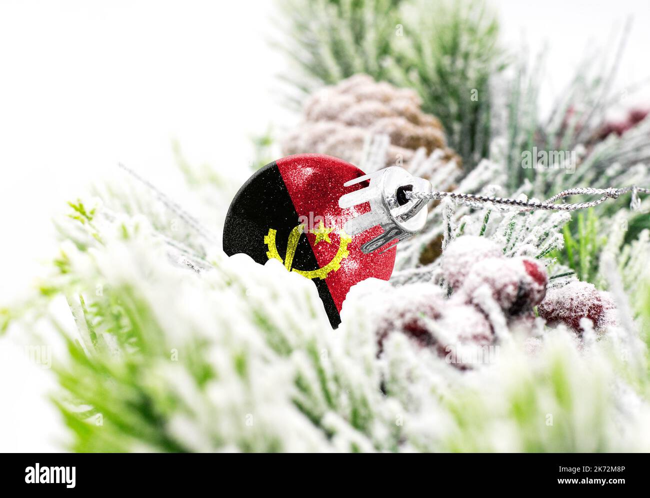 New Year's colorful background with a ball on which the flag of Angola ...