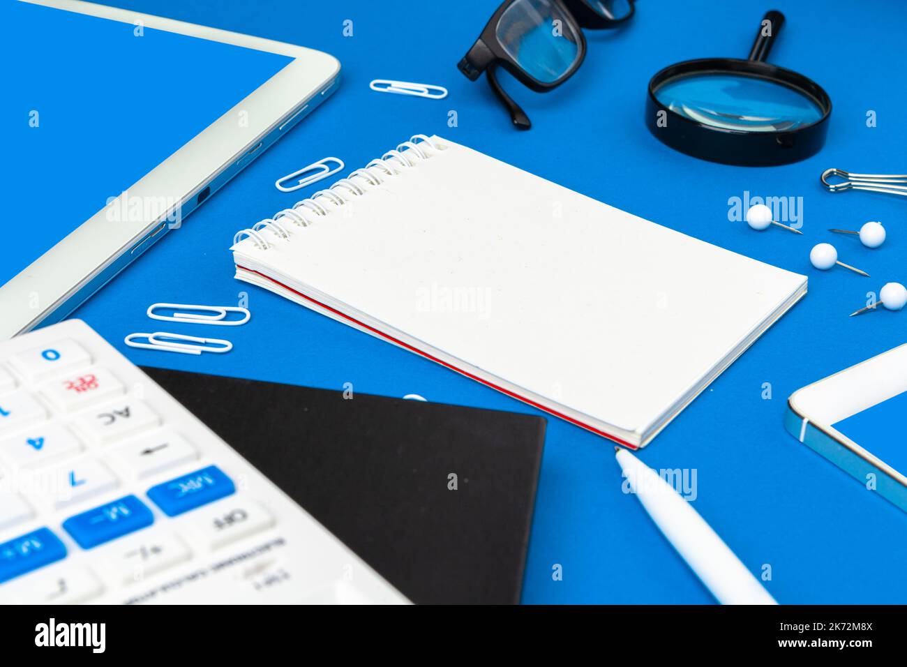 Flat lay, top view of blue office table desk. Workspace with blank note ...