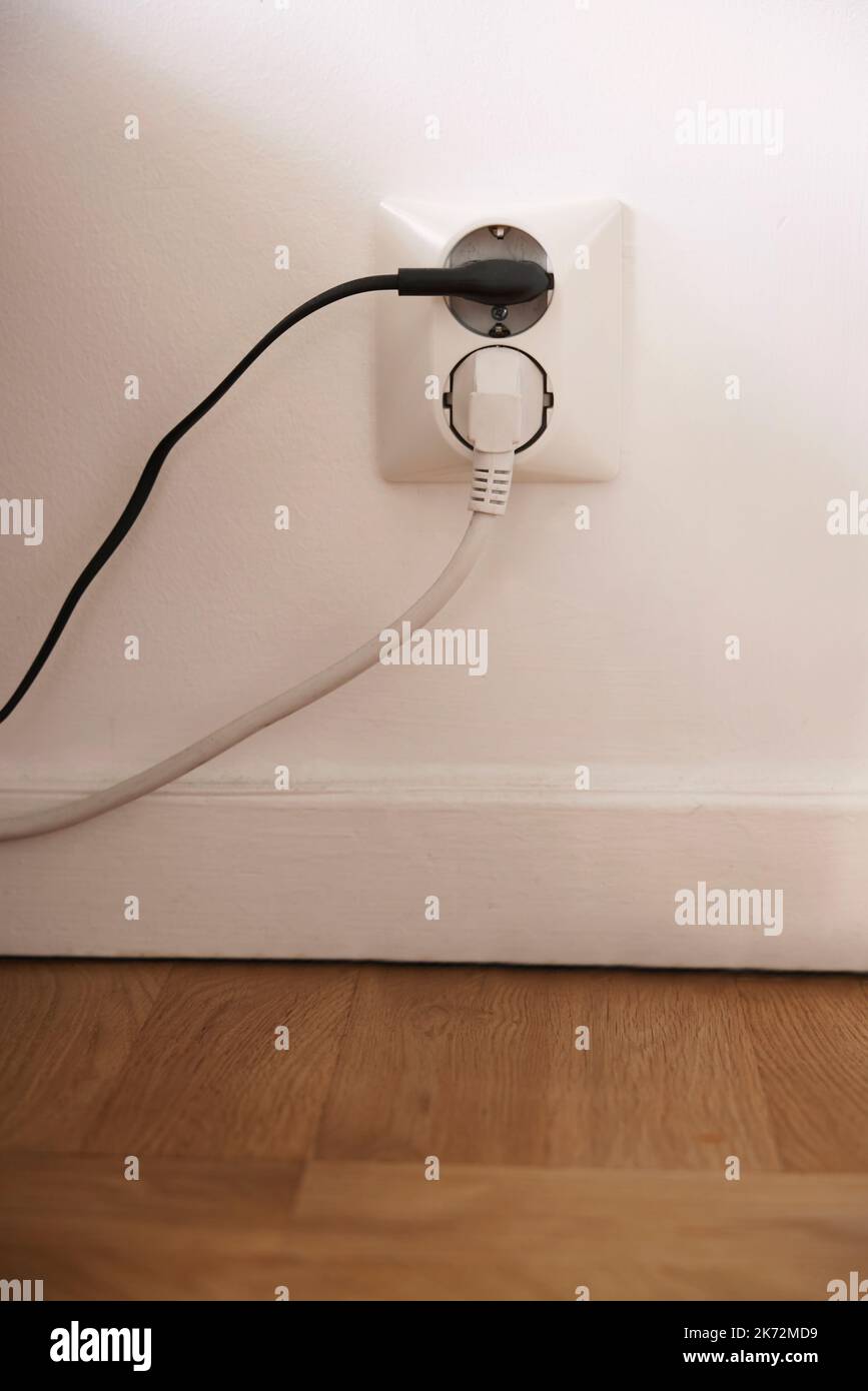 Plugs in wall outlet Stock Photo - Alamy