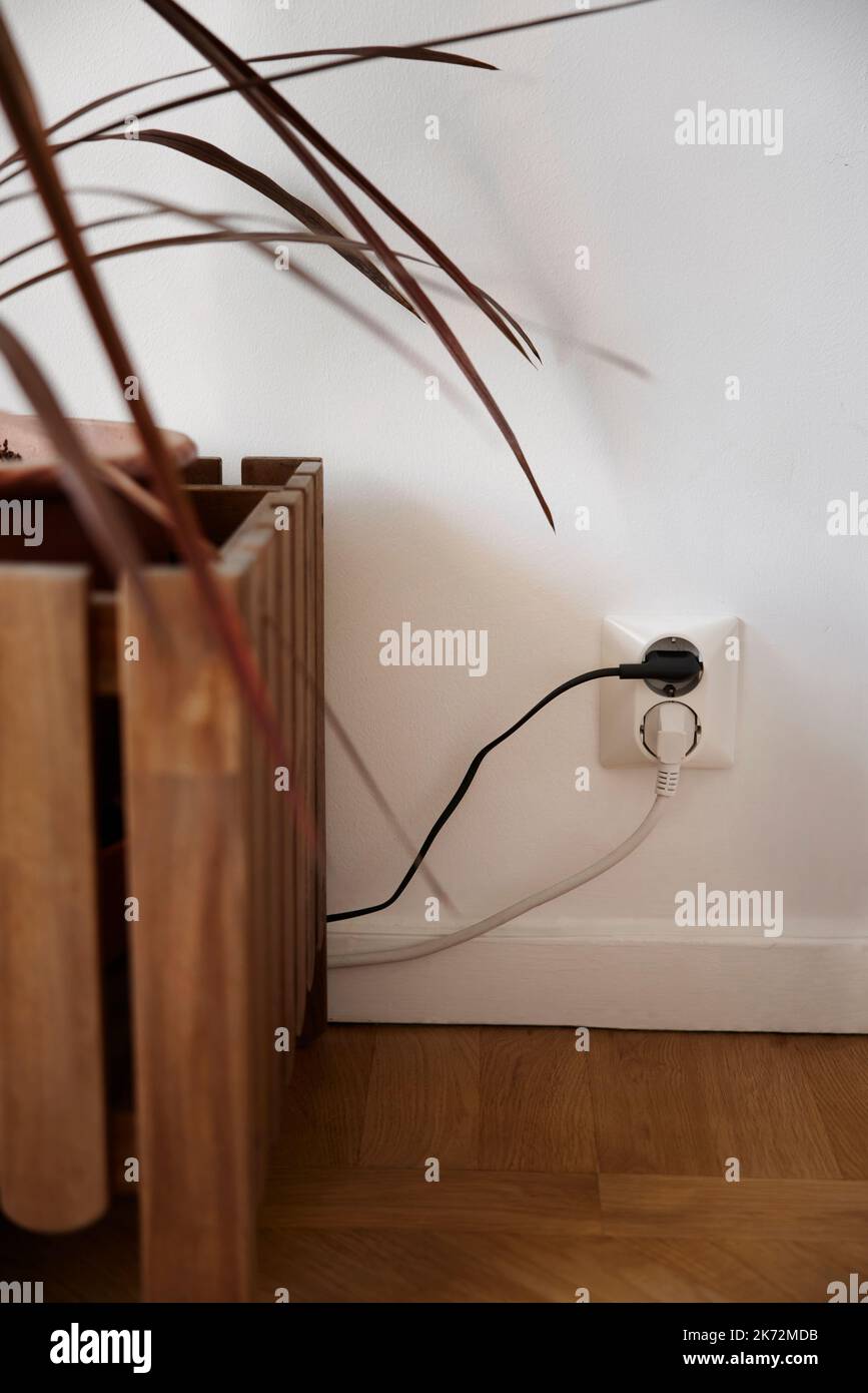 Plugs in wall outlet Stock Photo - Alamy