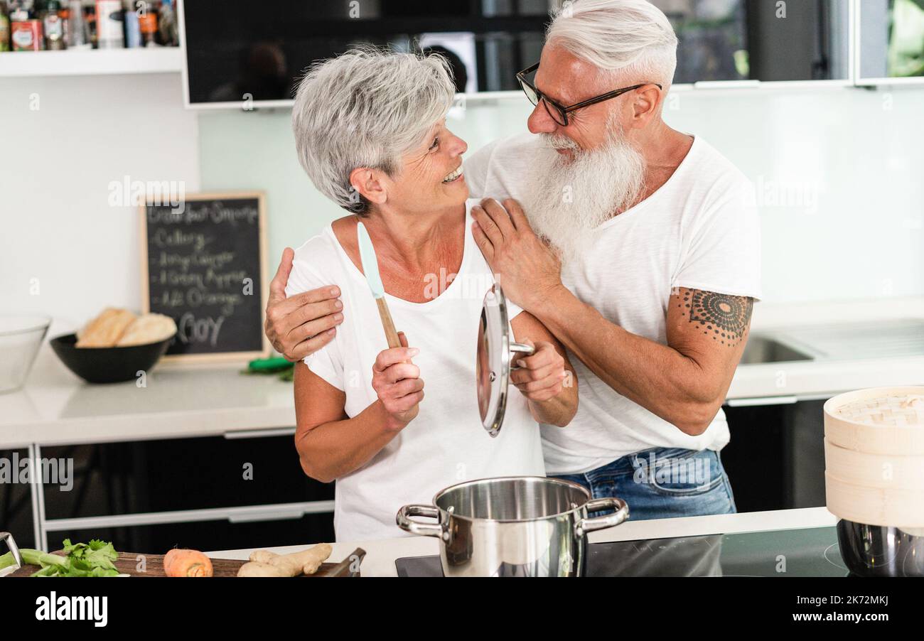 Happy senior couple enjoying and cooking healthy dinner together at ...