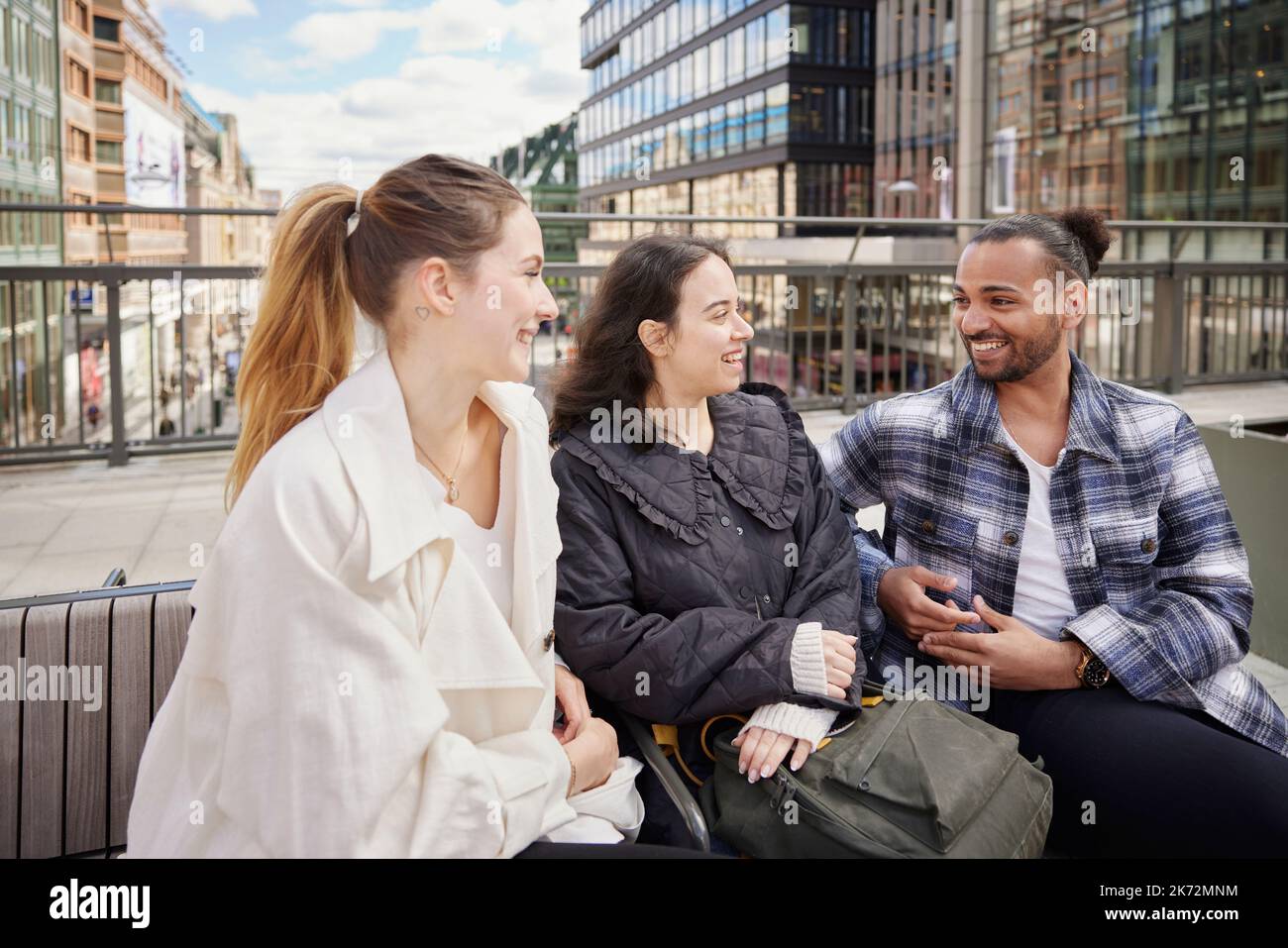 Smiling friends talking together Stock Photo - Alamy