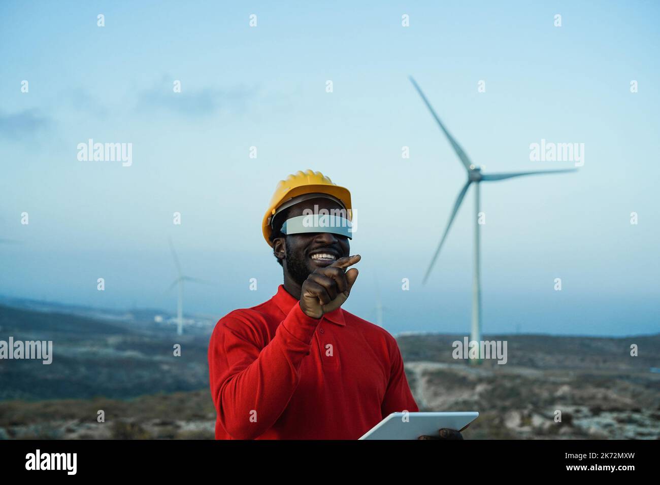 African engineer man using futuristic augmented reality glasses on a ...