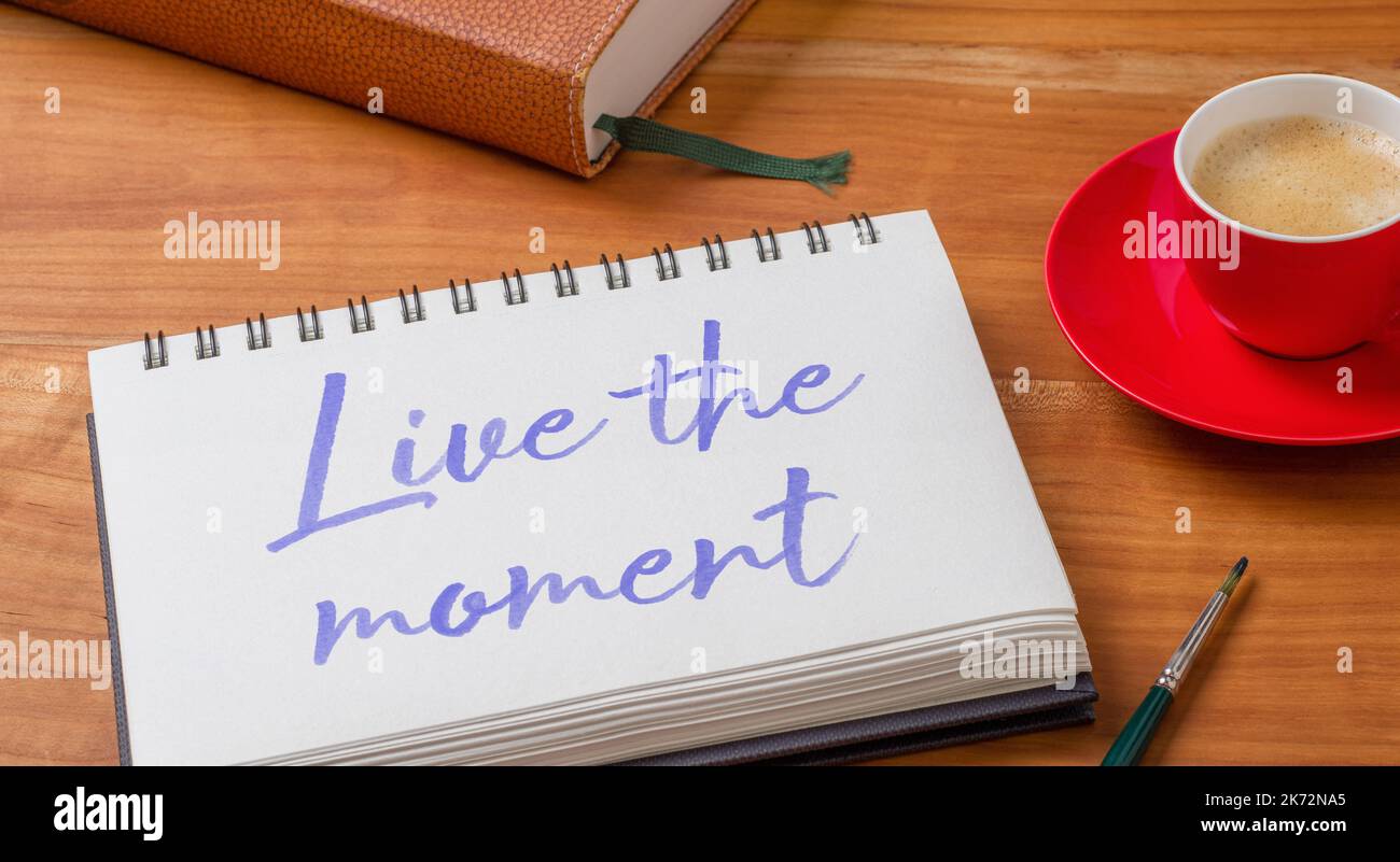 Notepad on a desk - Live the moment Stock Photo - Alamy