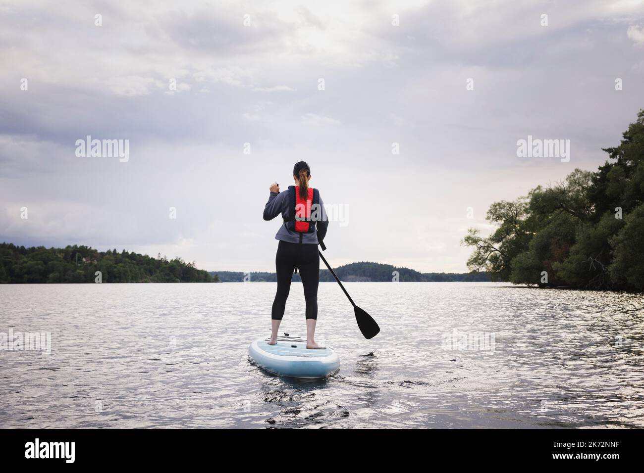 Woman paddle boarding on river Stock Photo - Alamy