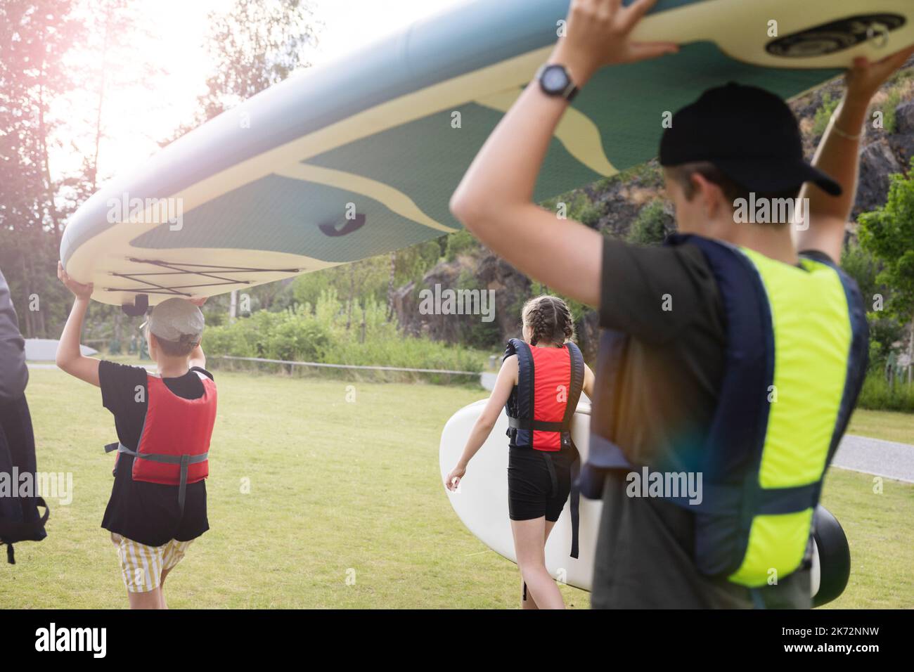Children carrying paddle board Stock Photo - Alamy