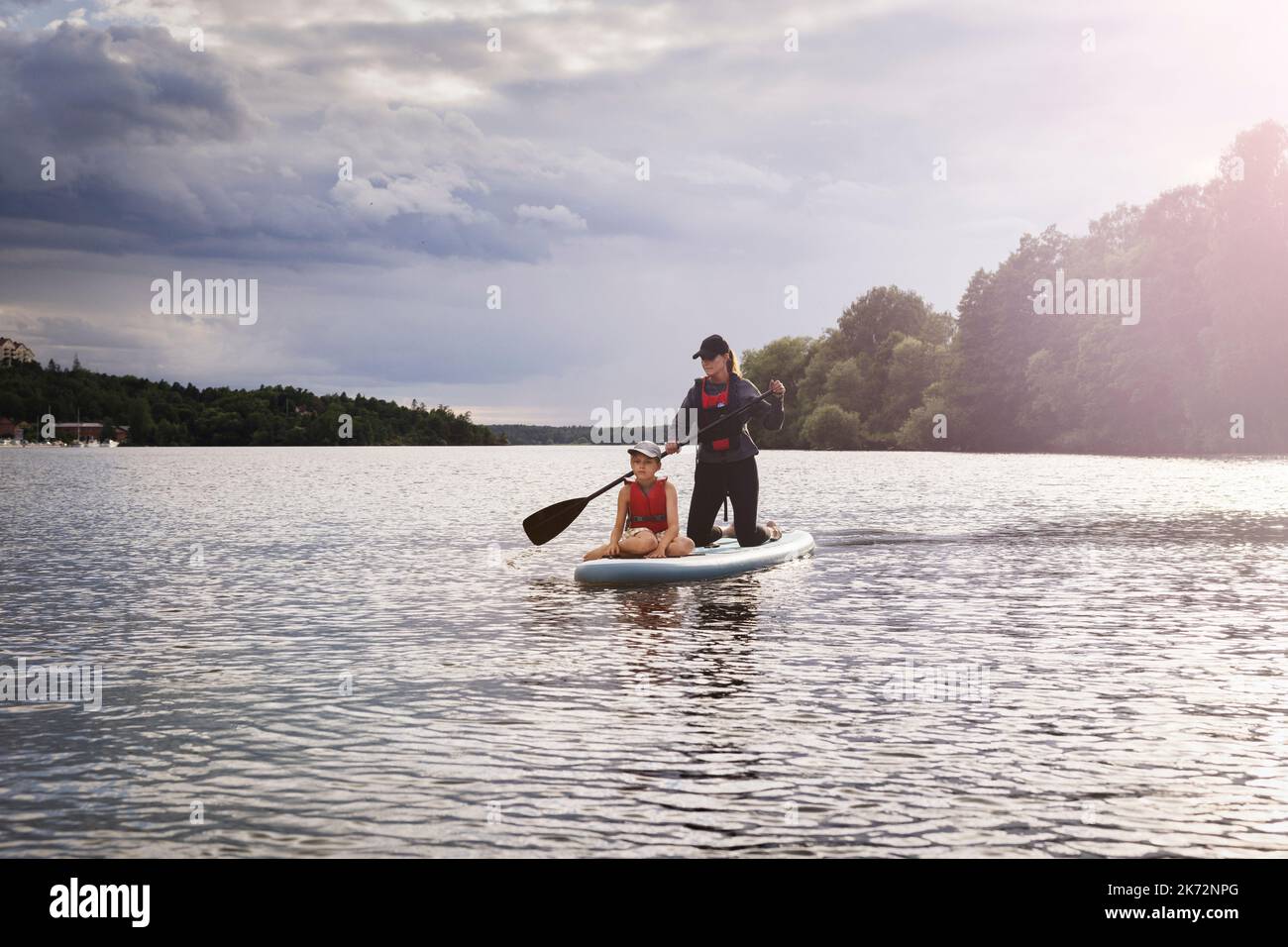 Mother and son paddle boarding Stock Photo - Alamy