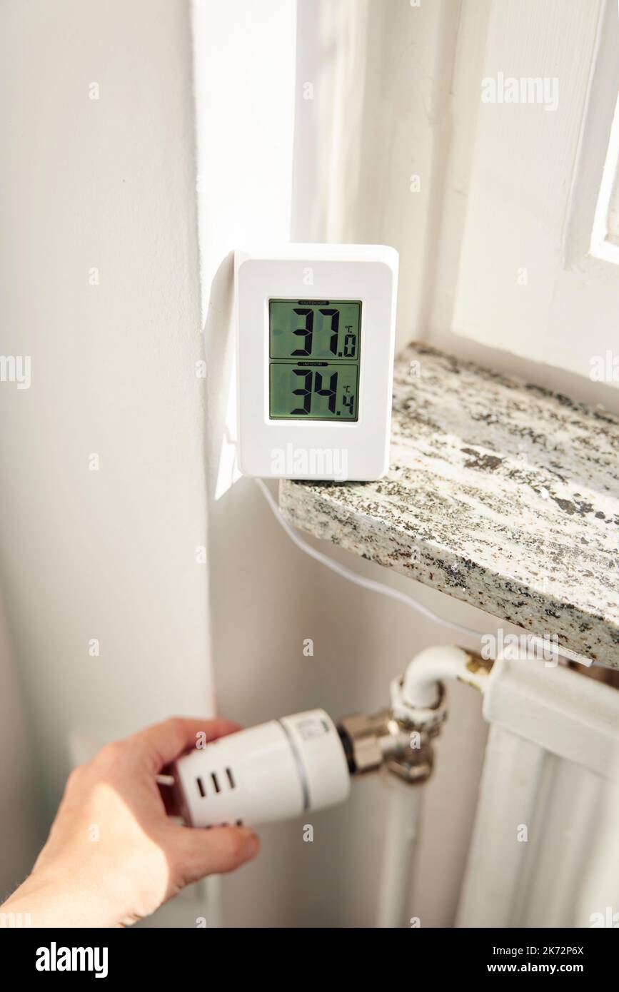 Woman adjusting radiator temperature Stock Photo - Alamy
