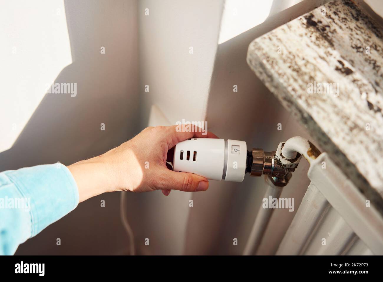 Woman adjusting radiator temperature Stock Photo - Alamy
