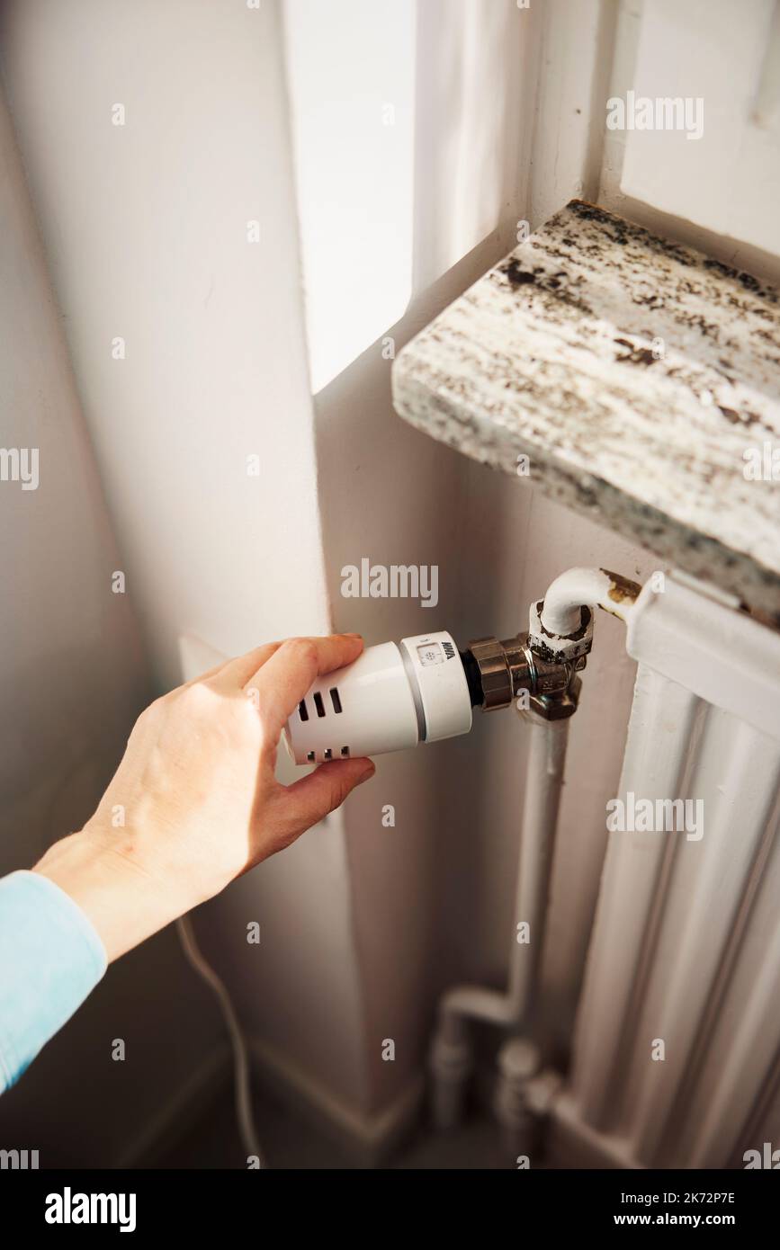 Woman adjusting radiator temperature Stock Photo - Alamy