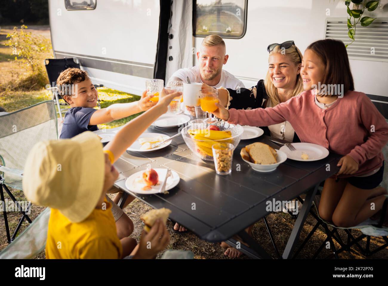 Family raising toast at picnic table Stock Photo - Alamy