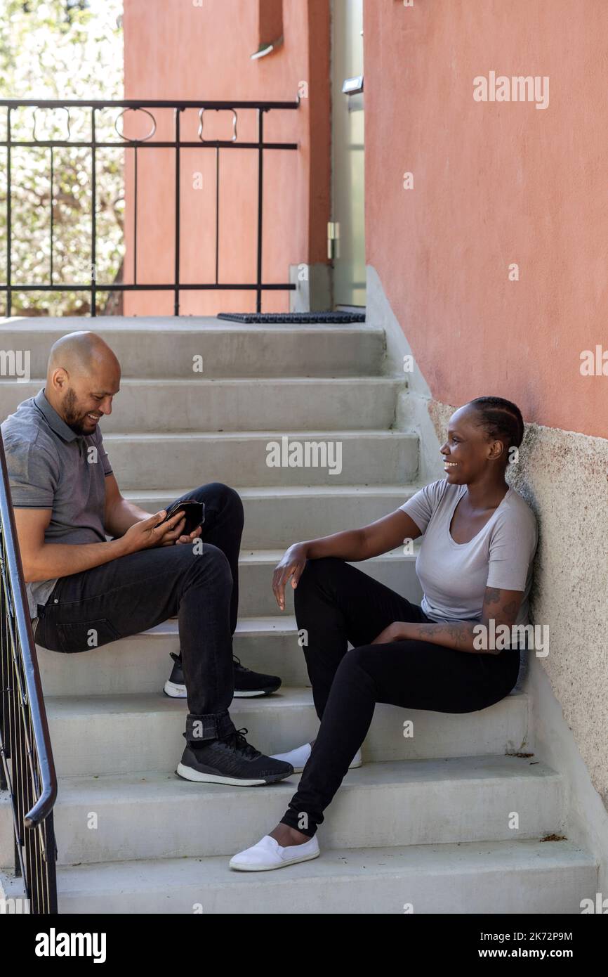 Mid adult couple sitting on steps Stock Photo - Alamy