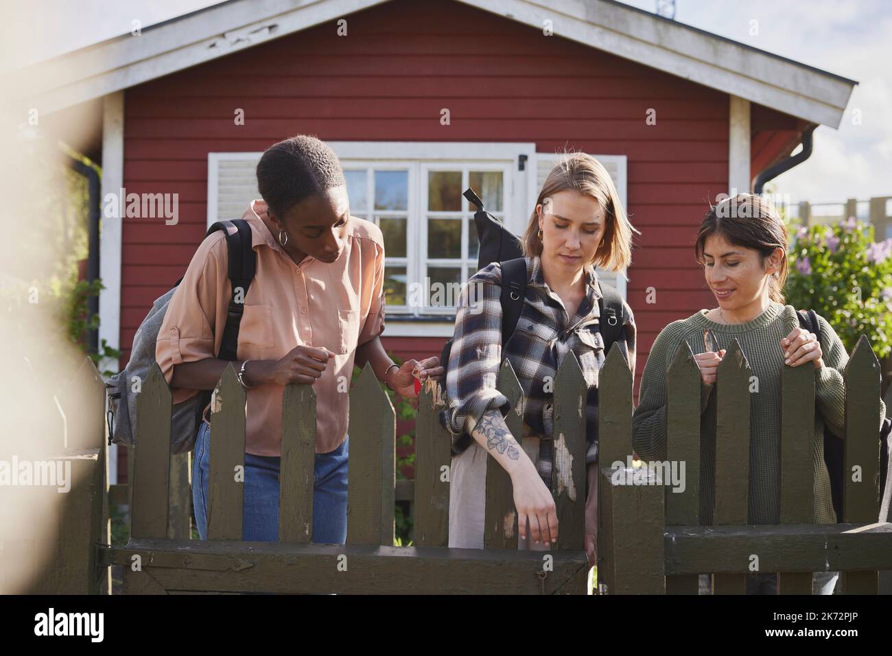 Female friends opening wooden gate Stock Photo - Alamy