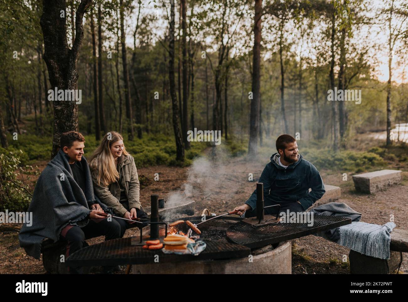 Friends having grill in forest Stock Photo - Alamy