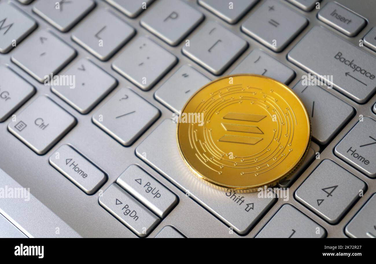 Solana single golden crypto coin on grey keyboard, close-up, copy space ...