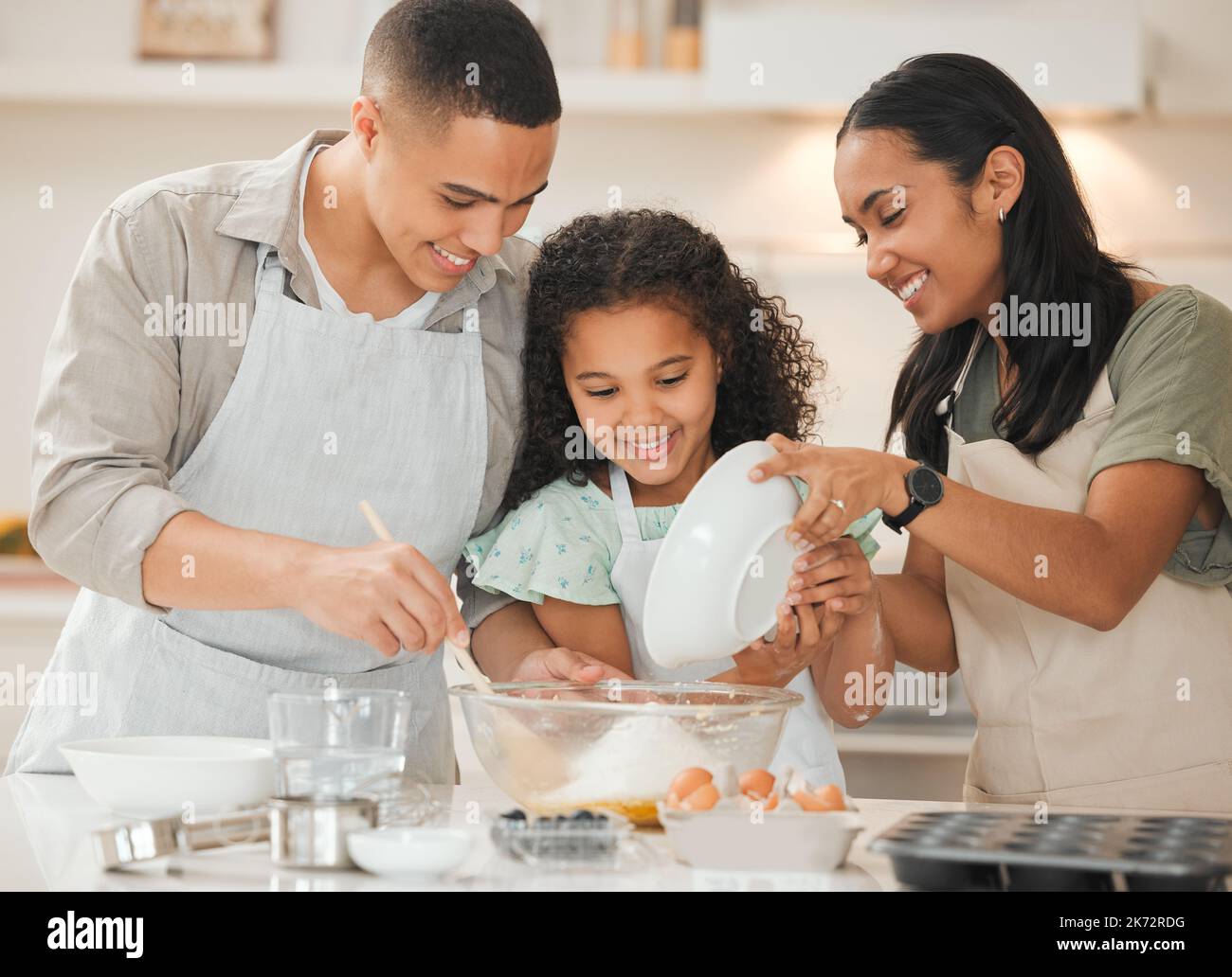 The kitchen is where memories are made. a young mother and father ...