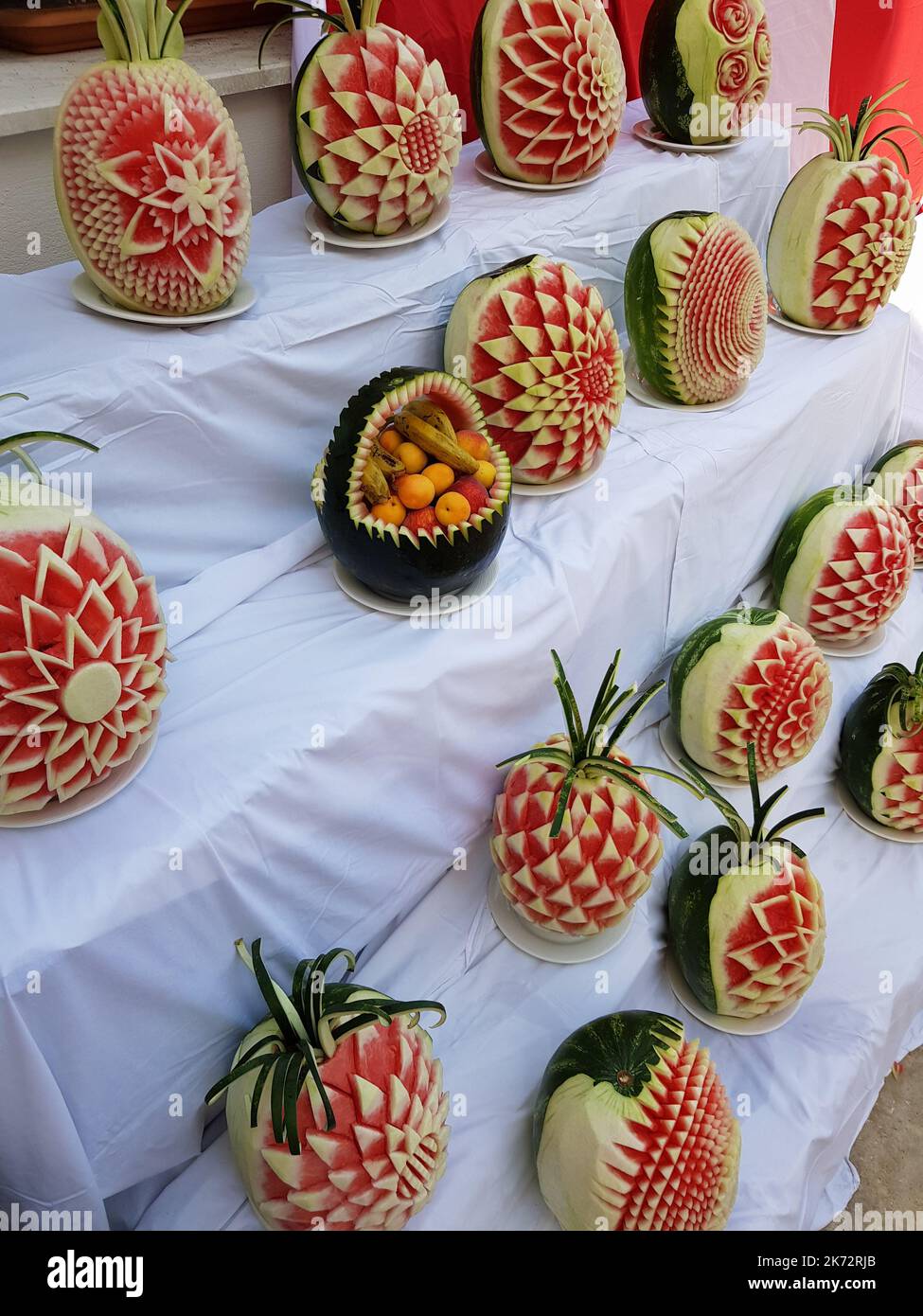 Large fresh watermelons with carved decorations on the counter. Decorative watermelon carving ...
